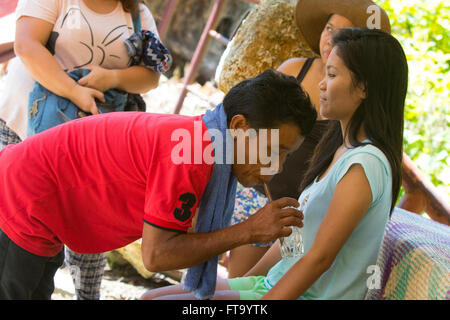 A Mananambal spiritual healer performs a healing ritual on a young ...