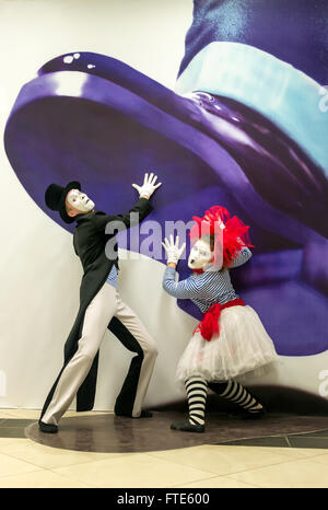 Two mime artists in red costumes, kissing scene. Pantomime theater ...
