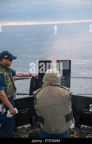 Gunner's Mate 3rd Class Gregory Hyun performs maintenance on a .50 ...