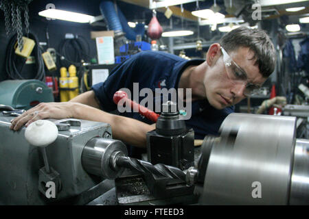 US Navy Machinery Repairman 2nd Class repairs a valve using a lathe ...