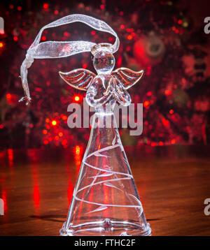 Praying angel in Christmas tree branches with Christmas red ornaments ...