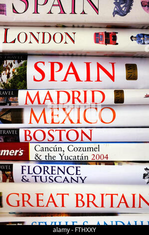 A stack of travel guide books for different countries and cities cross ...