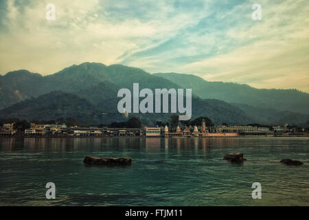 River Ganges, the famous bridge Laxman Jhula surrounded by temples and ...