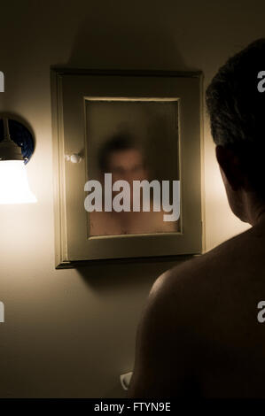 Man confronts his murky image in the mirror Stock Photo - Alamy