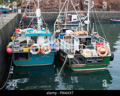 Fishing boats in Dunbar Harbour with Castle Dunbar East Lothian Stock ...