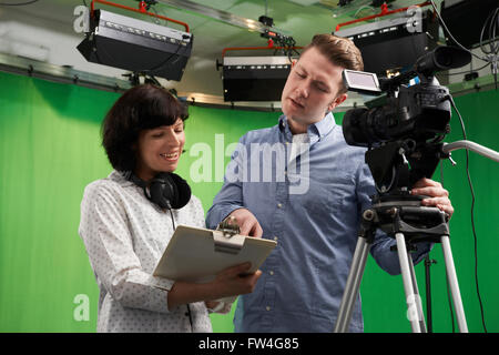 A cameraman and female studio floor manager at work during the ...