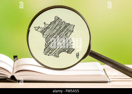 France with a pencil drawing of a french map in a magnifying glass ...