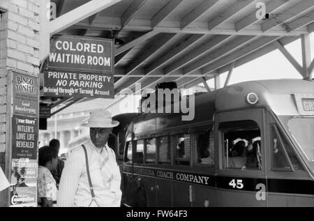'Colored Waiting Room' sign. African Americans stand under a Jim Crow ...