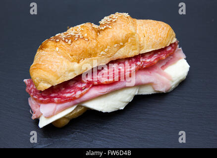 Cornetto savory filling with salami on wooden table seen from above ...