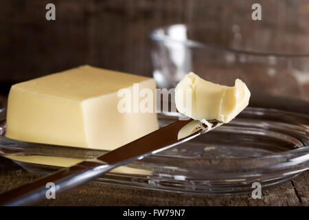 Butter Margarine block in a wooden tray with herbs. White wooden ...