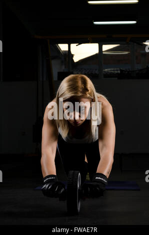 Muscular woman doing intense core workout in gym. Strong female doing ...