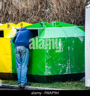 Homeless man digging in a garbage dumpster for food Stock Photo - Alamy
