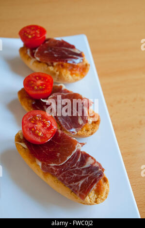 bread toast with spanish ham and tomato on a tray Stock Photo - Alamy