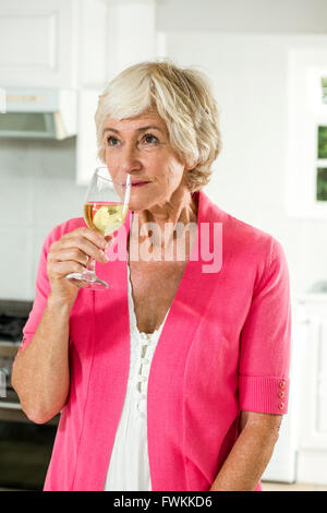 Thoughtful mature woman drinking wine while looking away at home Stock ...