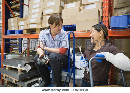 Caucasian workers talking in warehouse Stock Photo - Alamy