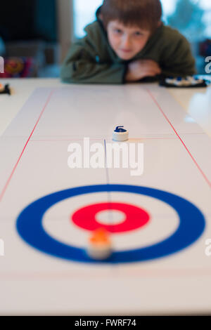 Table curling game being played by child Stock Photo - Alamy