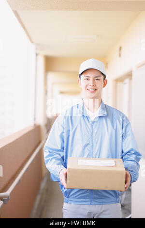 Young Japanese delivery man with box Stock Photo - Alamy