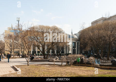 People walk along Chistoprudny boulevard during sunset in Moscow ...