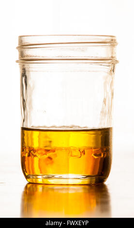 Oil sitting atop corn syrup in a glass jar Stock Photo - Alamy