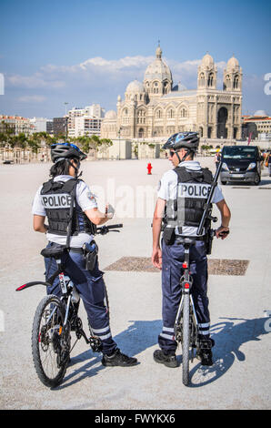 A French police woman officer on duty holding a walkie-talkie radio to ...