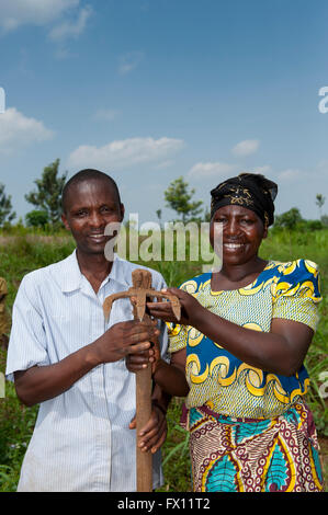 Rwandan farming couple with a hoe used in the fields to weed crops ...