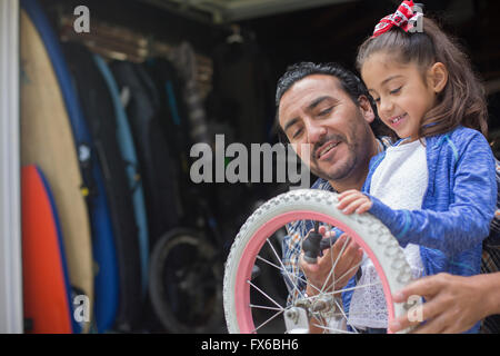 man teaching girl how to repair bicycle Stock Photo - Alamy