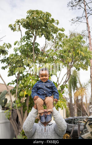 African american father assisting son in digging dirt for planting ...