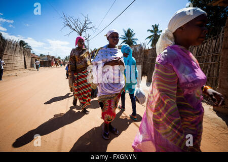 Mozambique, women walking in the street in traditional colored clothes ...