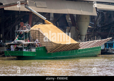 Boat transporting rice husks on the Mekong River, Vietnam Stock Photo ...