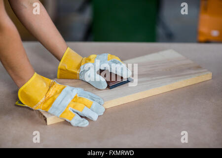 Female carpenter rubbing wood with sanding block Stock Photo - Alamy