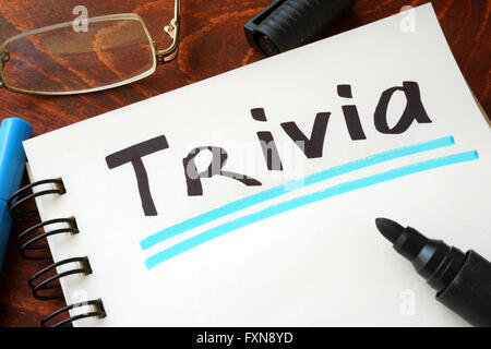 Trivia concept. Word Trivia written on a gray business card in golden ...