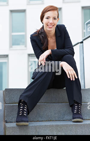 Portrait of a happy female student sitting at the desk in university ...