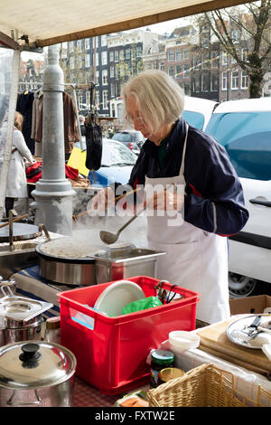 Making crepes pancakes at a food market. A hand is serving savoury ...