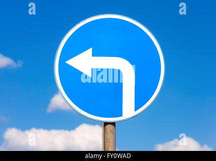 Road sign Turn left against the blue sky Stock Photo - Alamy