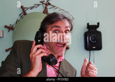 smiling man answering an old fashioned telephone Stock Photo - Alamy