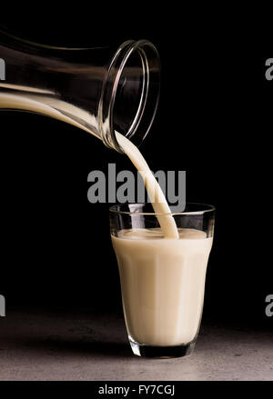 pour oat milk in glass on wood background with copy space, wide photo ...