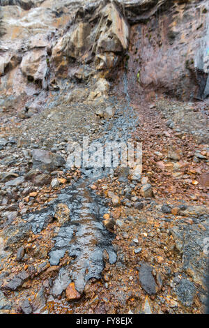 Crude oil seeping out of a rock face in an old quarry in Napo Province ...