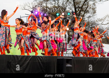 Young Japanese teenage and child dance troupe wearing orange cropped ...