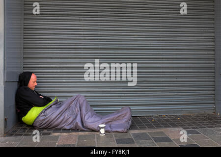 Homeless man person sleeping rough outdoors on a park bench in the ...