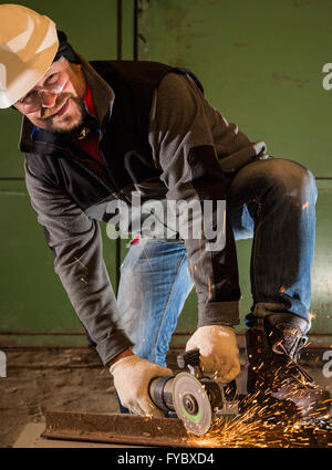 Worker working of a grinding machine with a lot of sparks Stock Photo ...