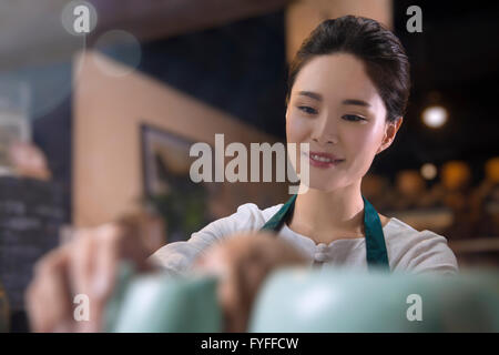 Antique shop owner arranging window display Stock Photo - Alamy