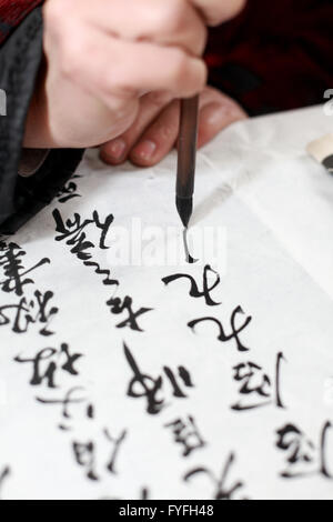 Hand holding Chines brush pen ，writing Chinese characters Stock Photo ...