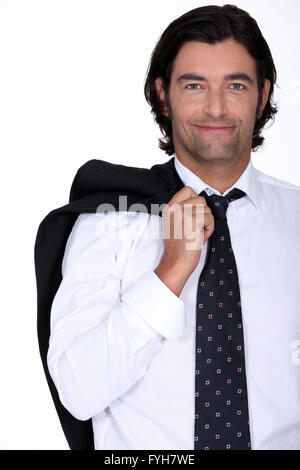 Man with a suit jacket flung over his shoulder pointing at a screen ...