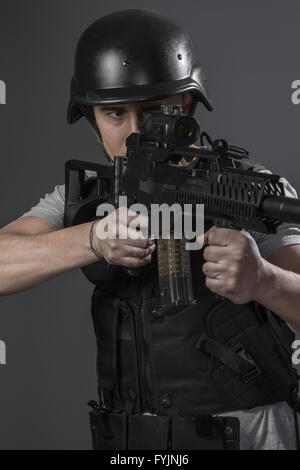 Playing, paintball sport player wearing protective helmet aiming pistol ...
