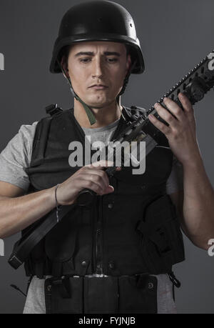 Man player shooting with a paintball gun hiding behind wooden shelter ...