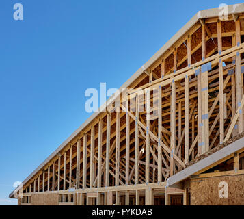 Gable end of a new-build home with scaffolding visible. Against blue ...