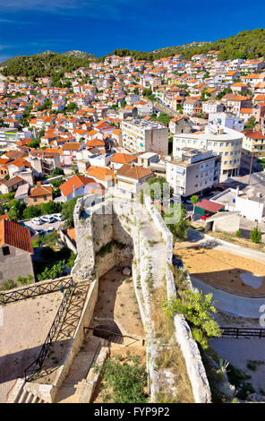 A vertical aerial view of beautiful mountain silhouettes under a bright ...