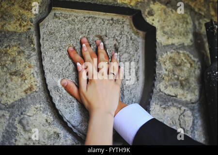 Wedding rings on a stone, a bouquet of pink flowers Stock Photo - Alamy