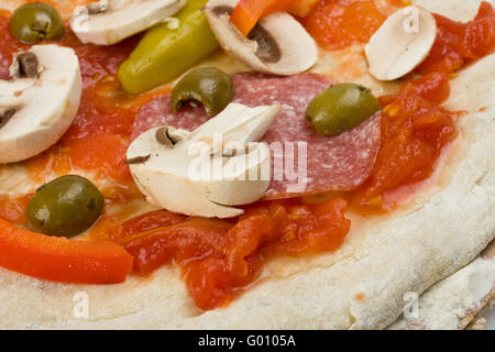 unbaked pizza prepared to bake on a wooden board Stock Photo - Alamy
