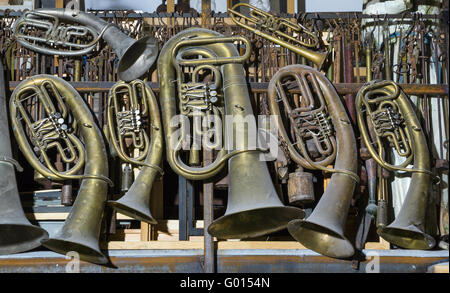 Old brass musical instruments and copper objects hanging on wall in ...